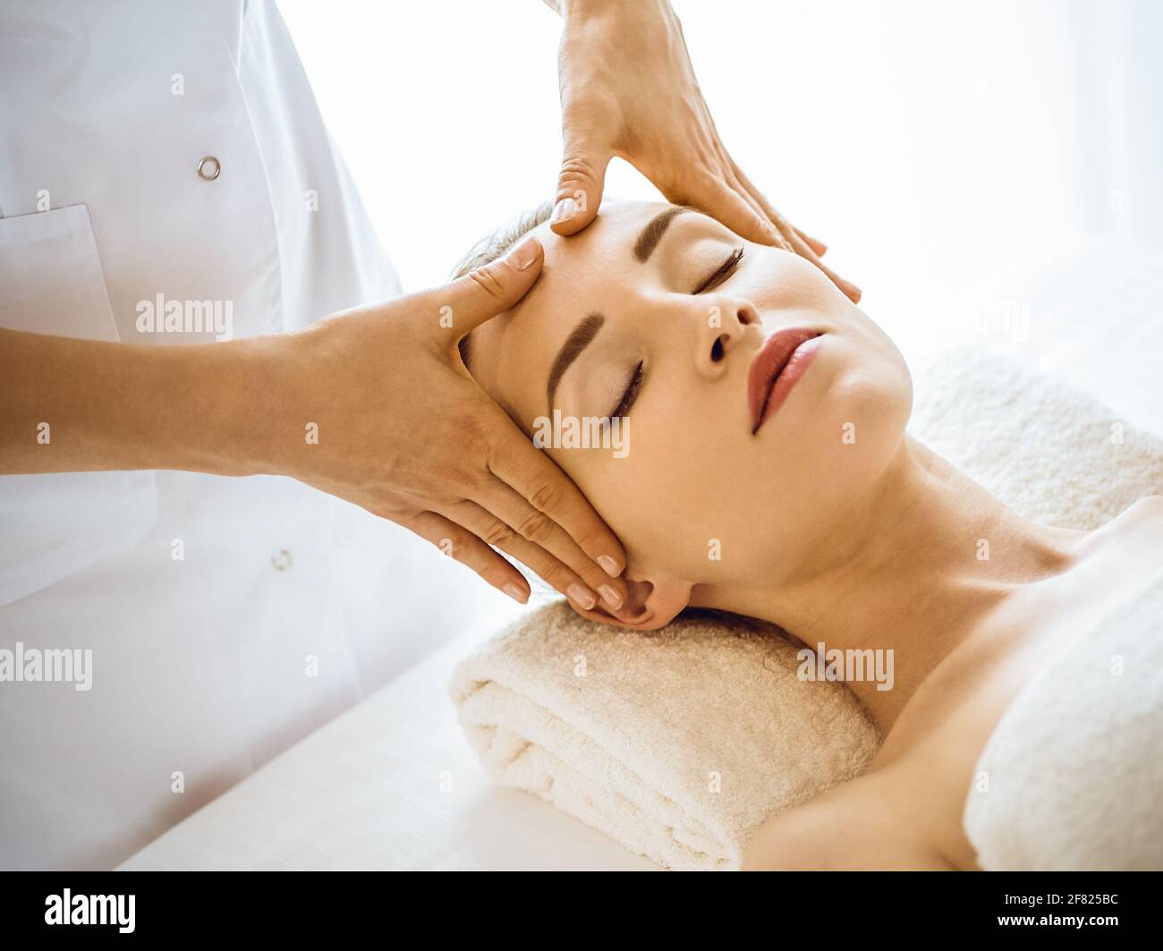 Beautiful Woman Enjoying Facial Massage With Closed Eyes In Spa Center