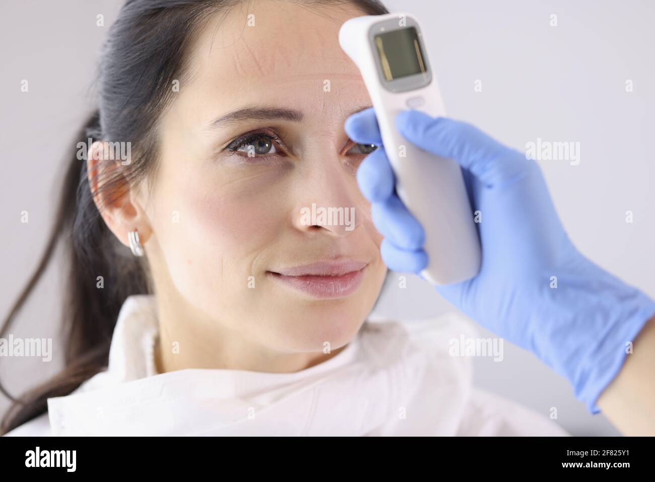 Woman doctor has her body temperature measured after work shift Stock ...