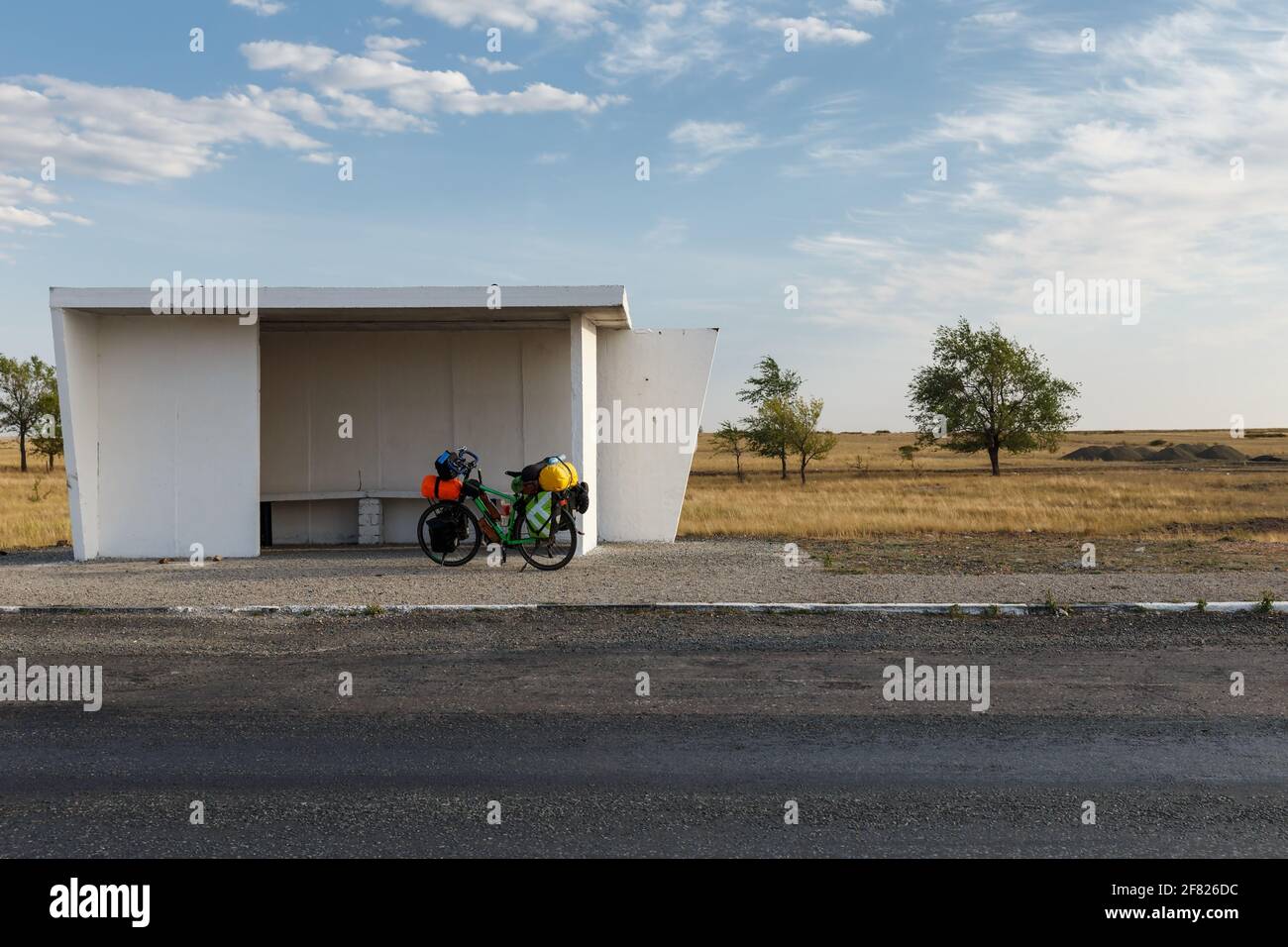 tourist bike stands at a bus stop in Kazakhstan. Bicycle with heavy ...