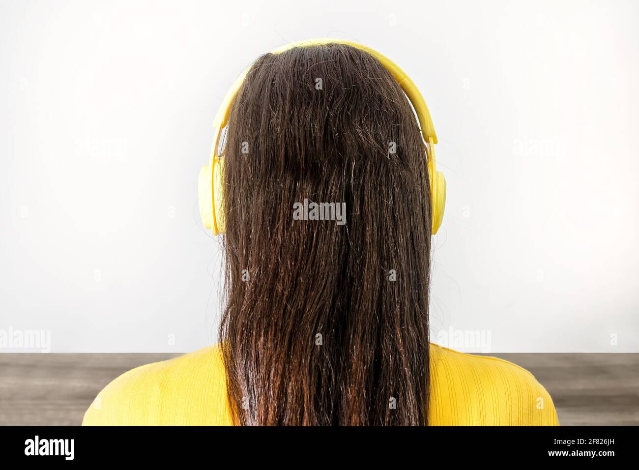 A back view of a woman's head wearing yellow headphones Stock Photo - Alamy