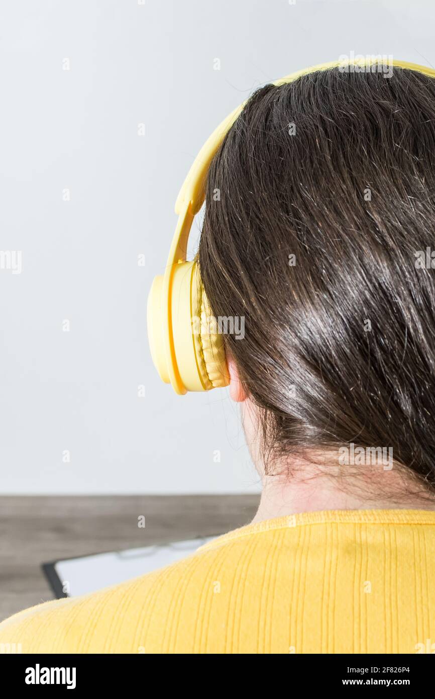 A back view of a woman's head wearing yellow headphones Stock Photo - Alamy