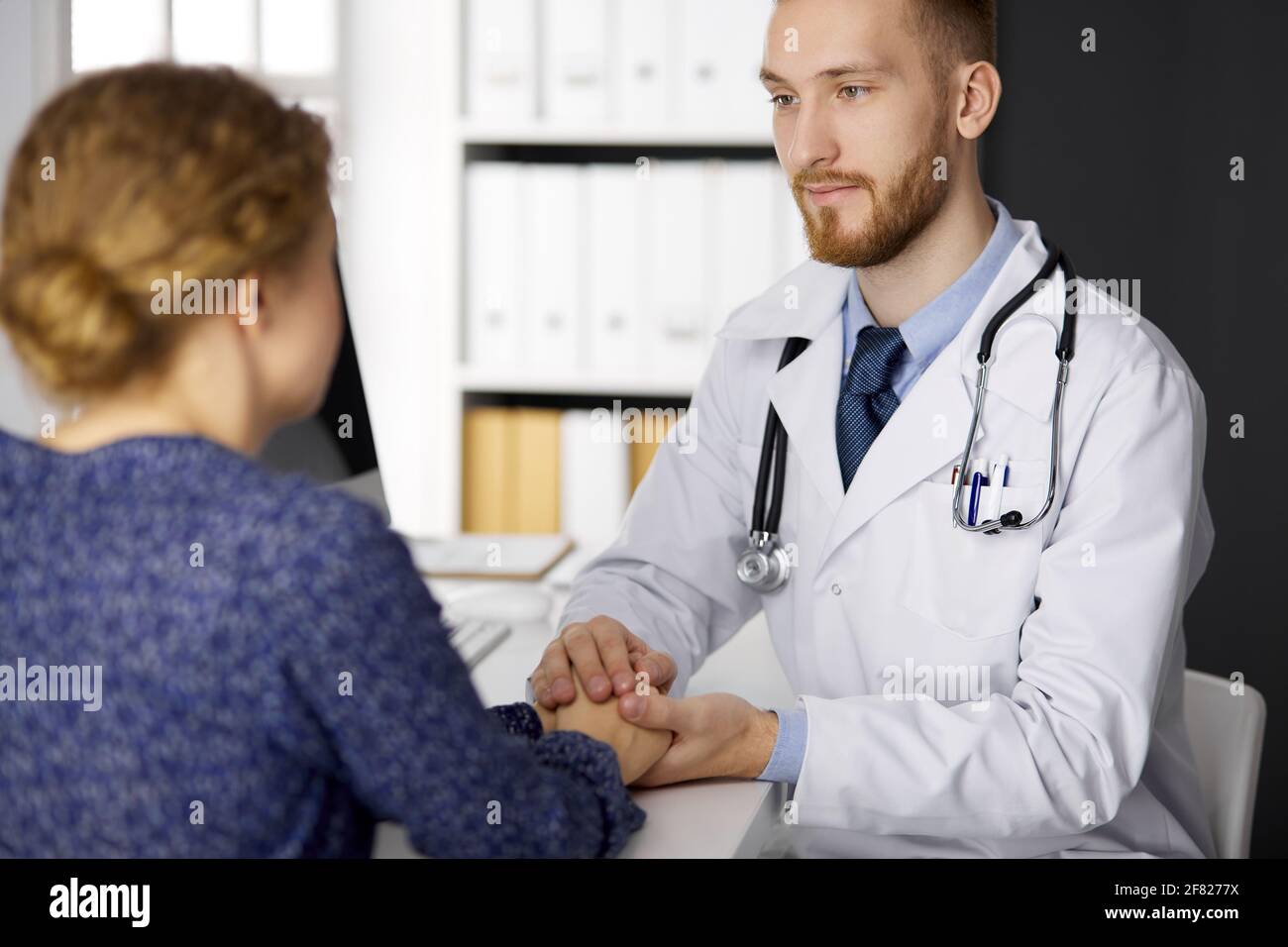 Friendly doctor reassuring his female patient. Medical ethics and trust ...