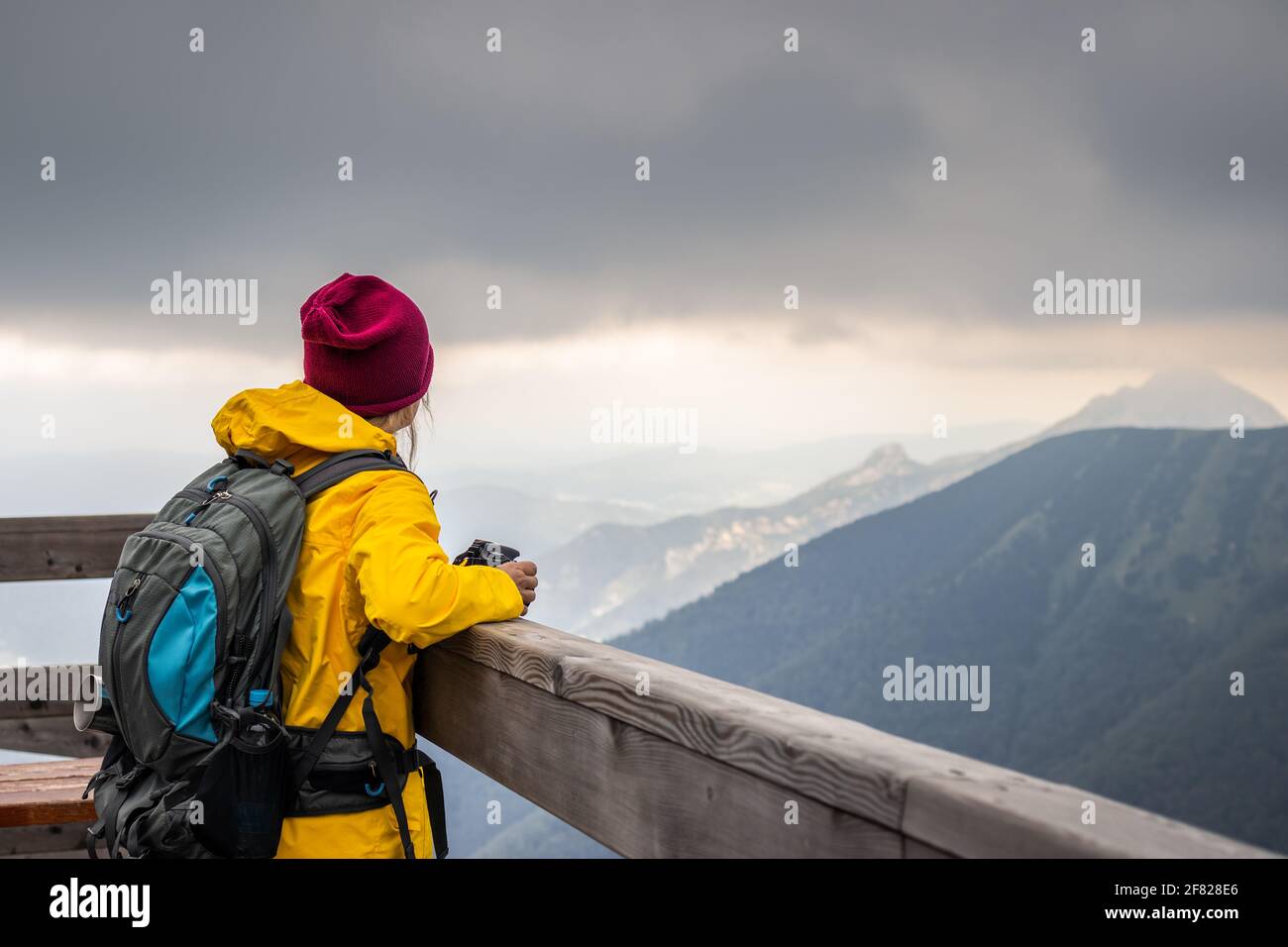 Adventure in nature. Hiker with camera looking at mountain range in bad ...