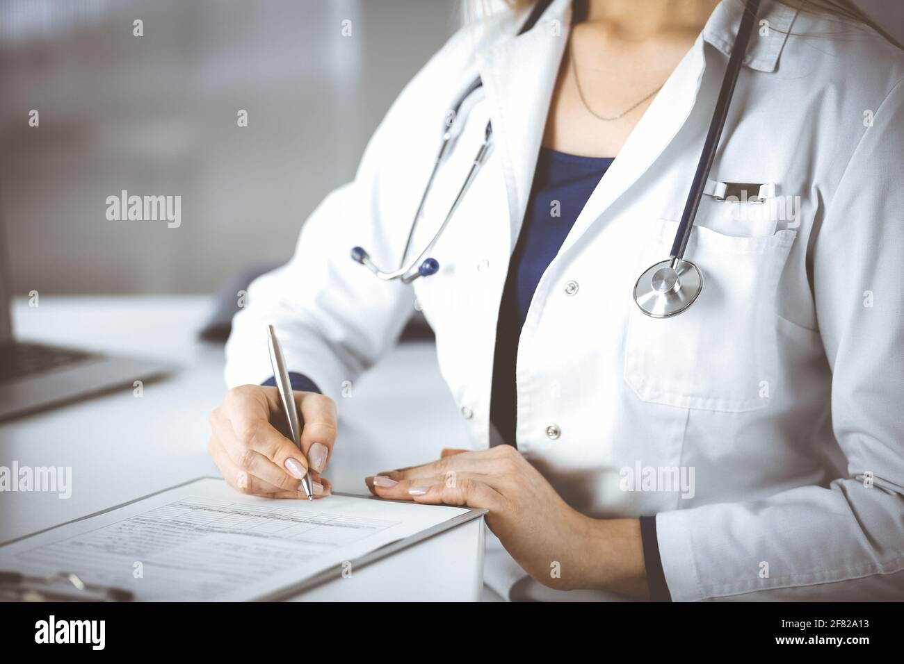 Unknown woman-doctor is prescribing some medication for her patient ...