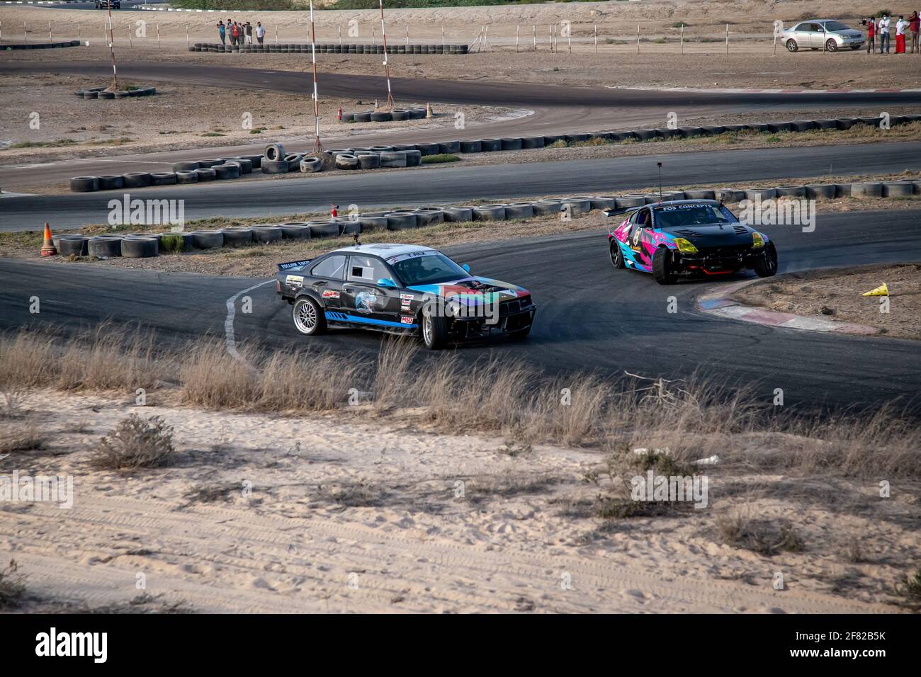 cars on tarmac tack drag racing with smoke in desert during day time ...