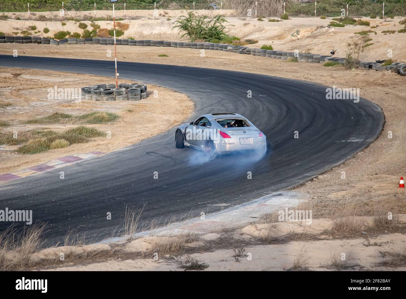 cars on tarmac tack drag racing with smoke in desert during day time ...