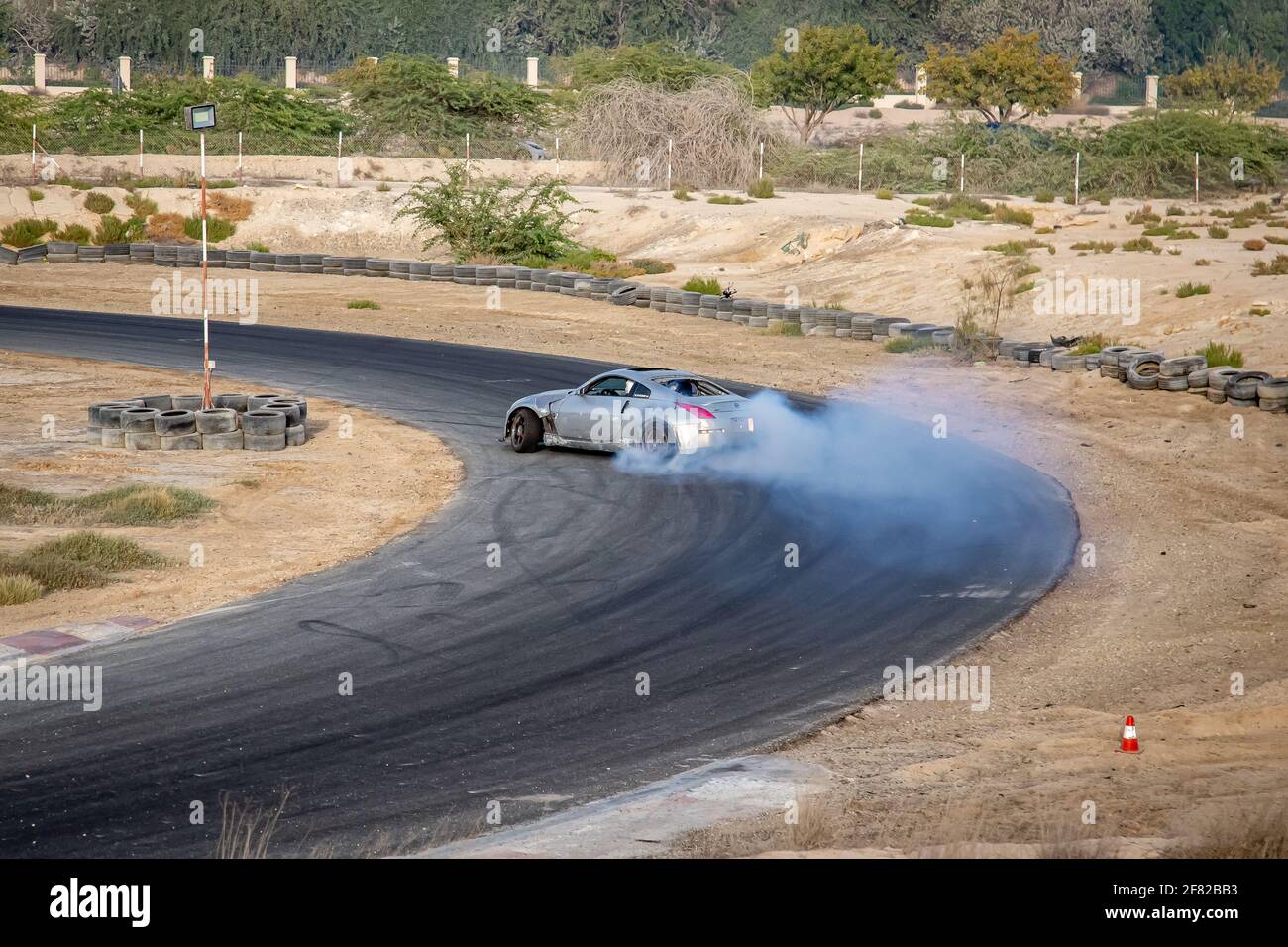 cars on tarmac tack drag racing with smoke in desert during day time ...
