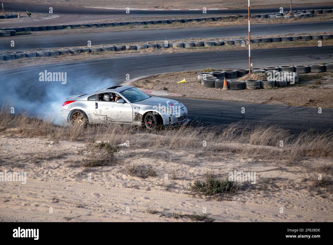 cars on tarmac tack drag racing with smoke in desert during day time ...