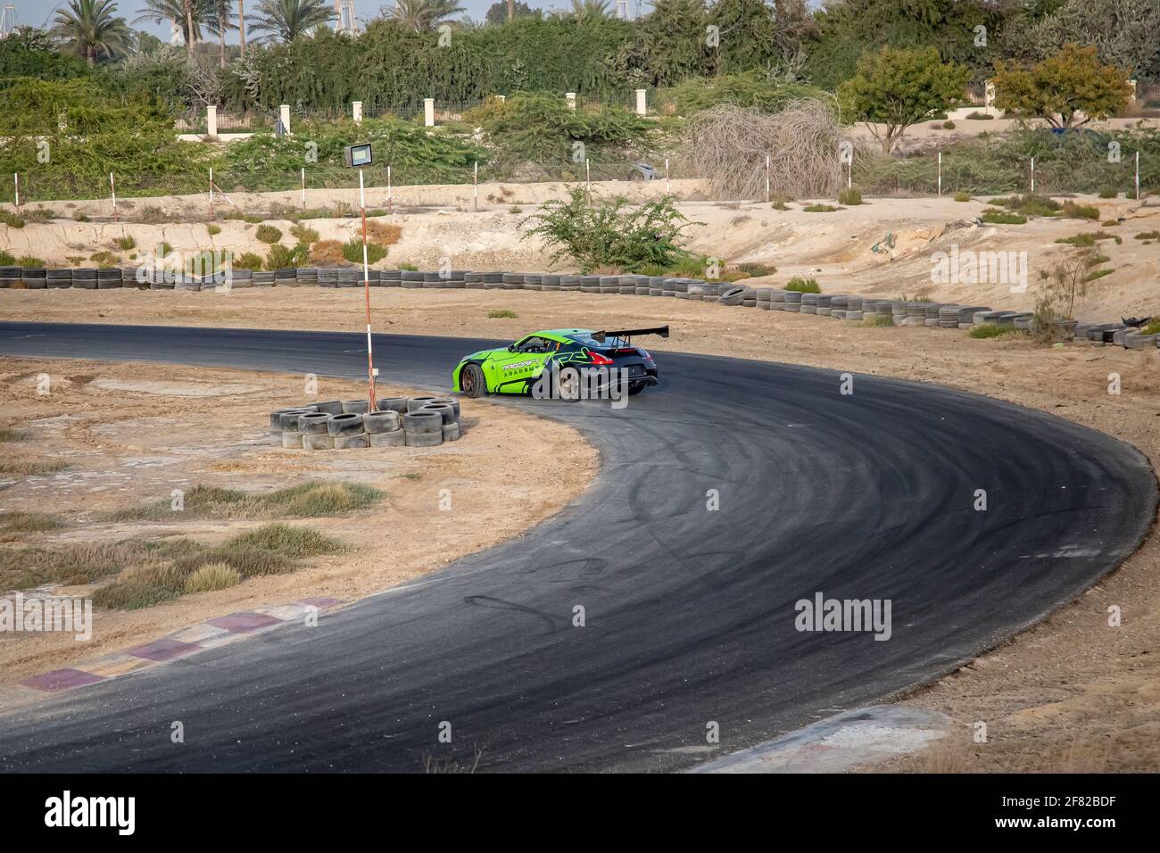 cars on tarmac tack drag racing with smoke in desert during day time ...