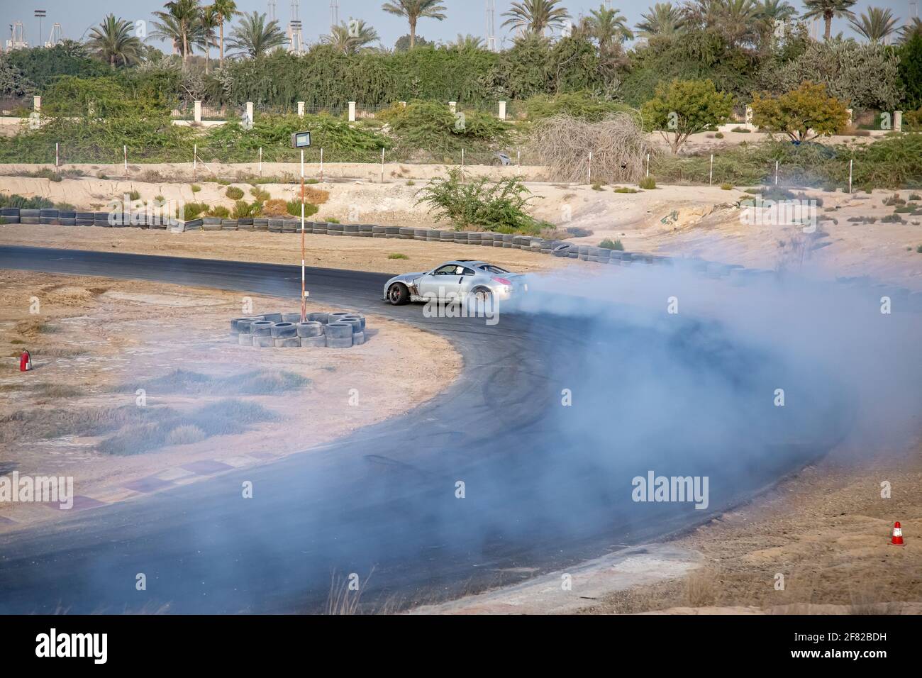 cars on tarmac tack drag racing with smoke in desert during day time ...