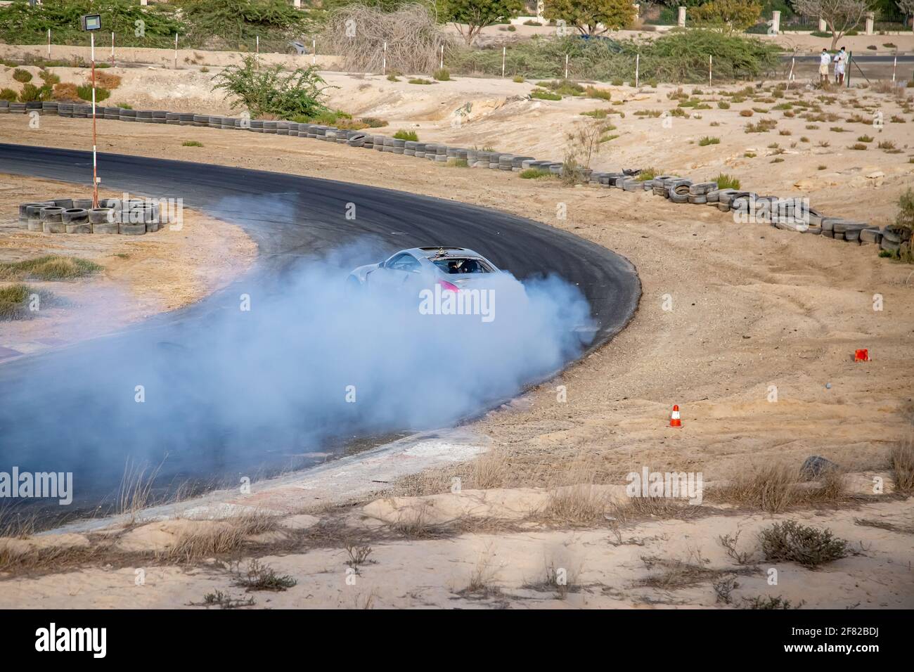 cars on tarmac tack drag racing with smoke in desert during day time ...