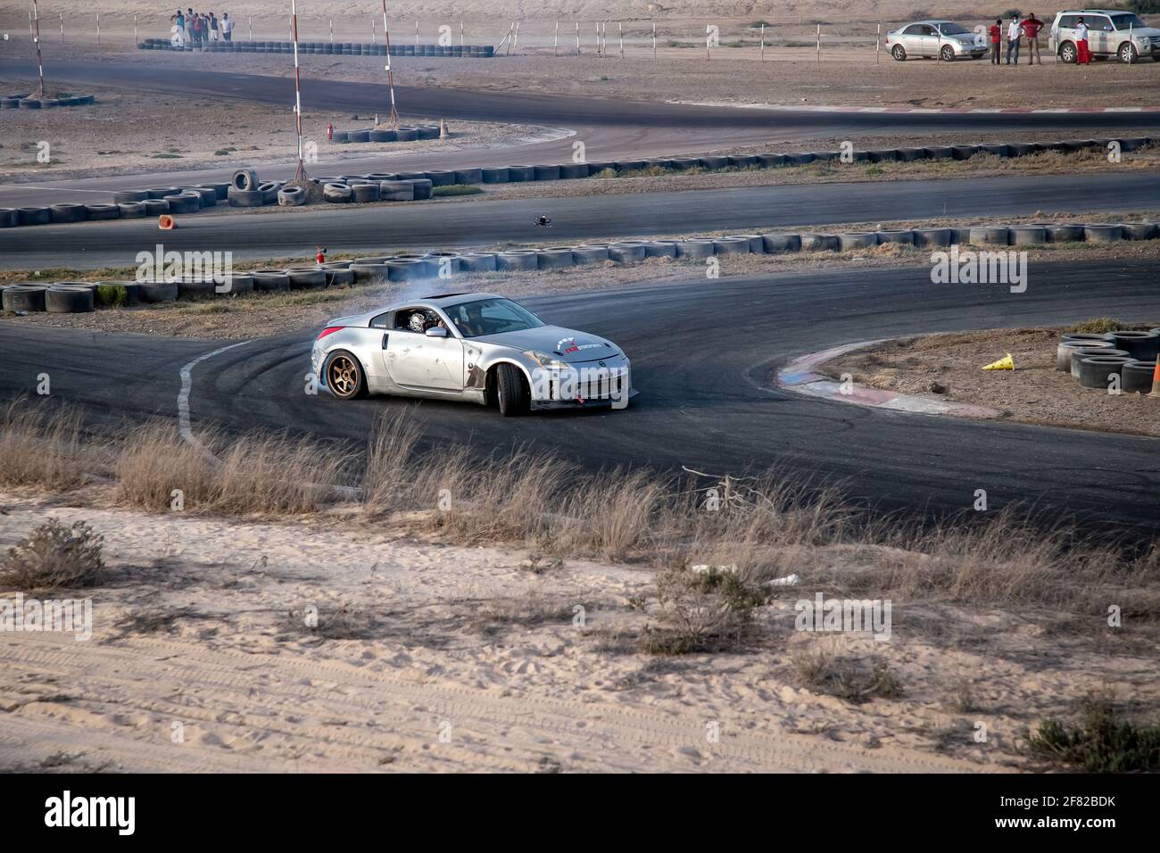 cars on tarmac tack drag racing with smoke in desert during day time ...
