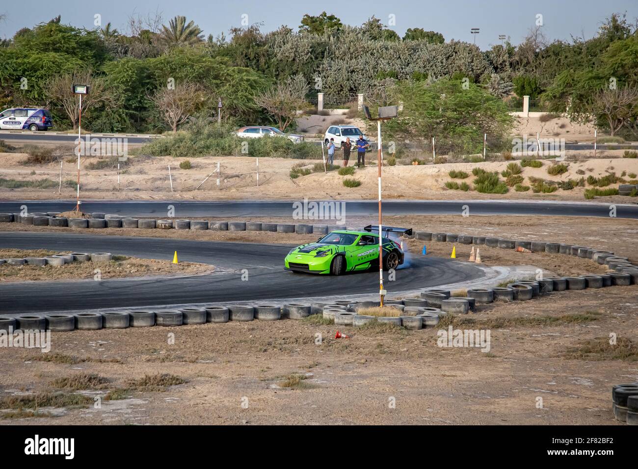 cars on tarmac tack drag racing with smoke in desert during day time ...