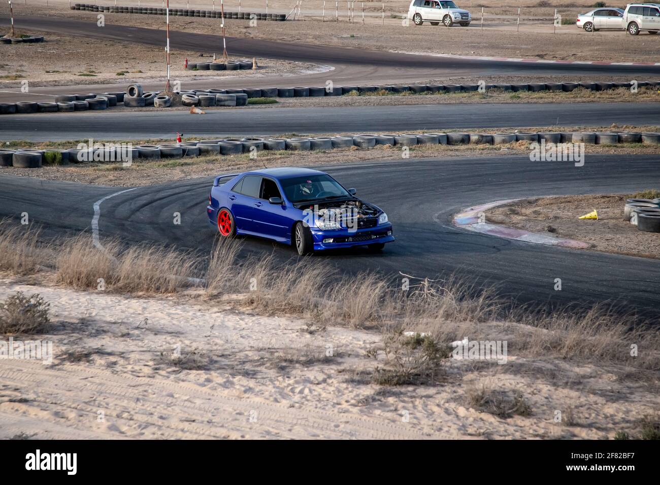 cars on tarmac tack drag racing with smoke in desert during day time ...