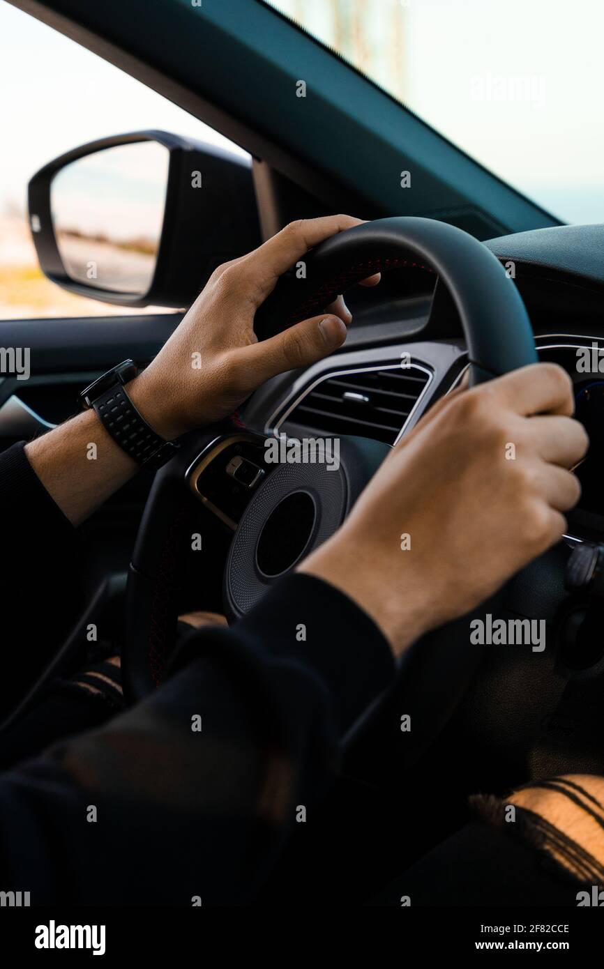 Close-up of hands holding the handlebars of a car, wearing a smart ...