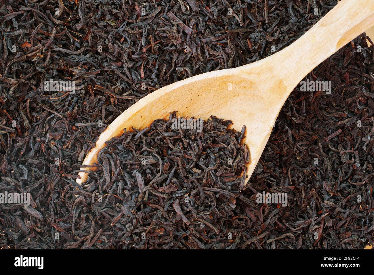macro of black loose long leaf tea with wooden spoon, top view Stock ...