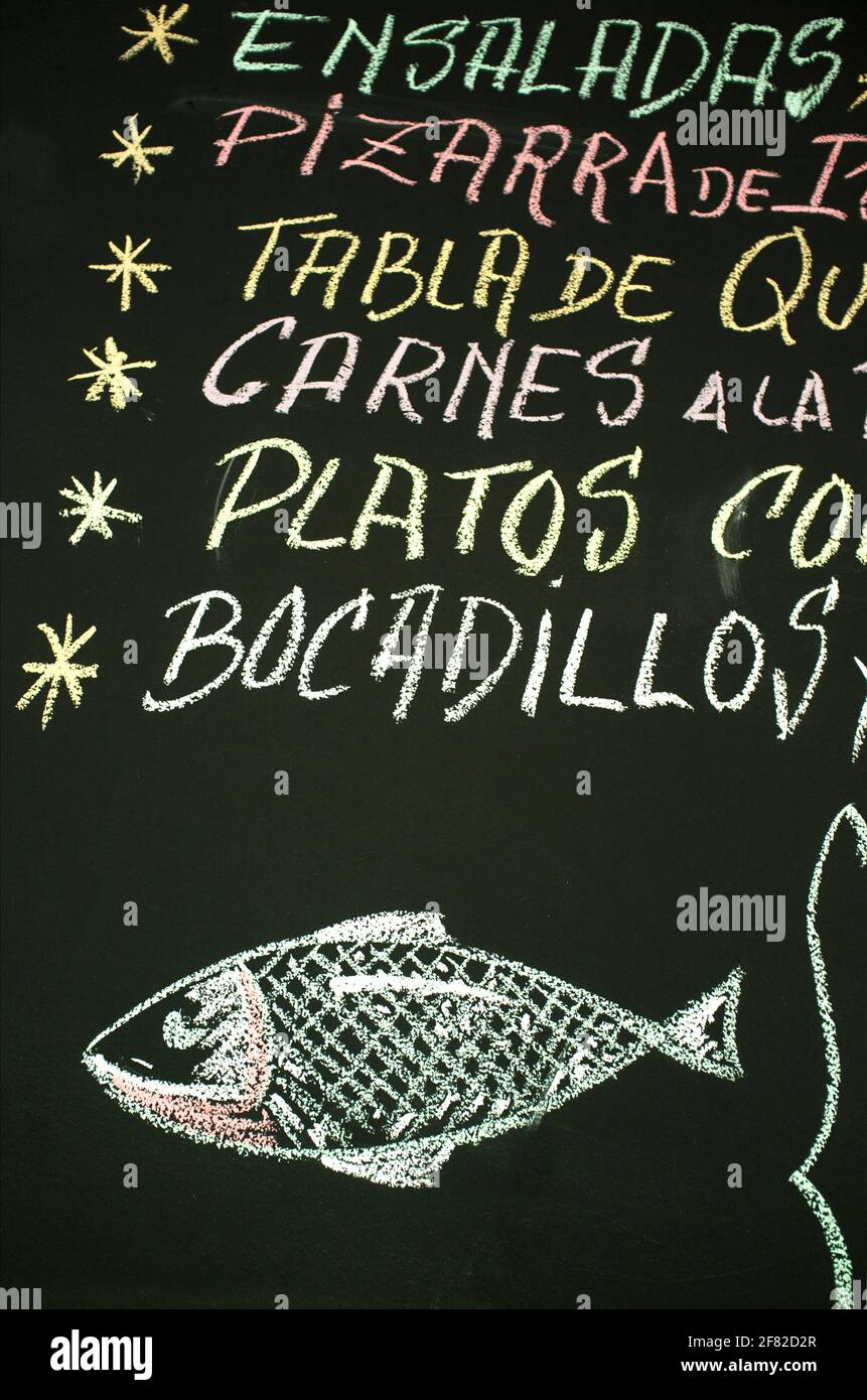 Restaurant menu board offering food with colorful drawings. Spanish ...