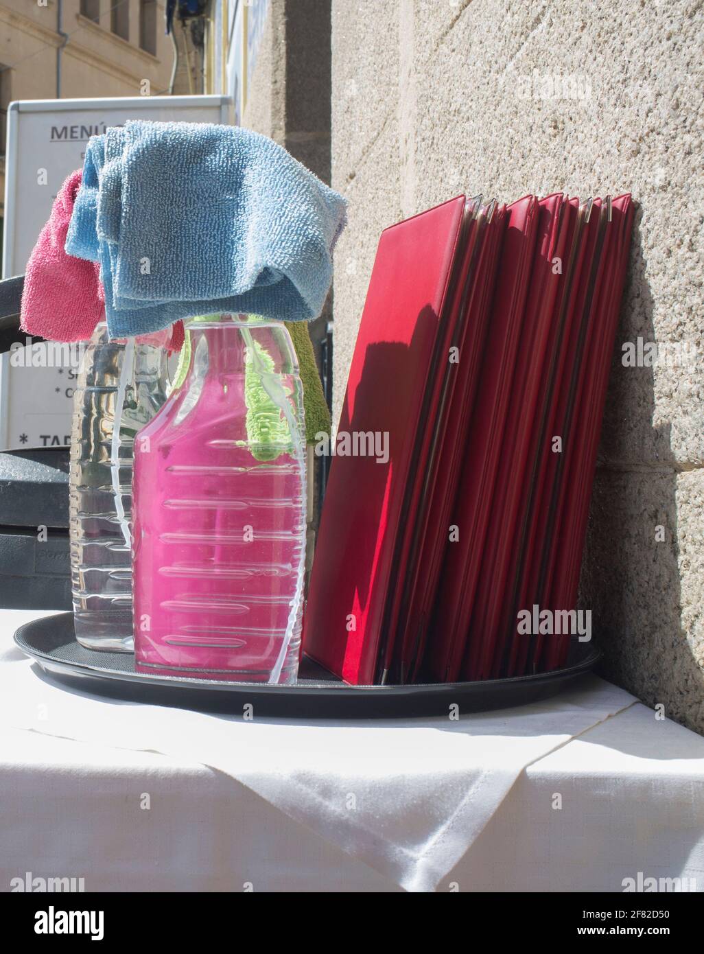 Waiter tray full of disinfectant spray products over restaurant terrace ...