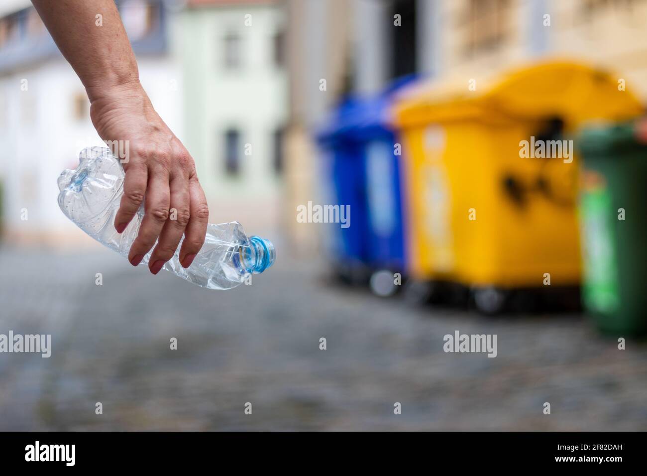 Evironmental issues. Hand holding plastic bottle at city street ...