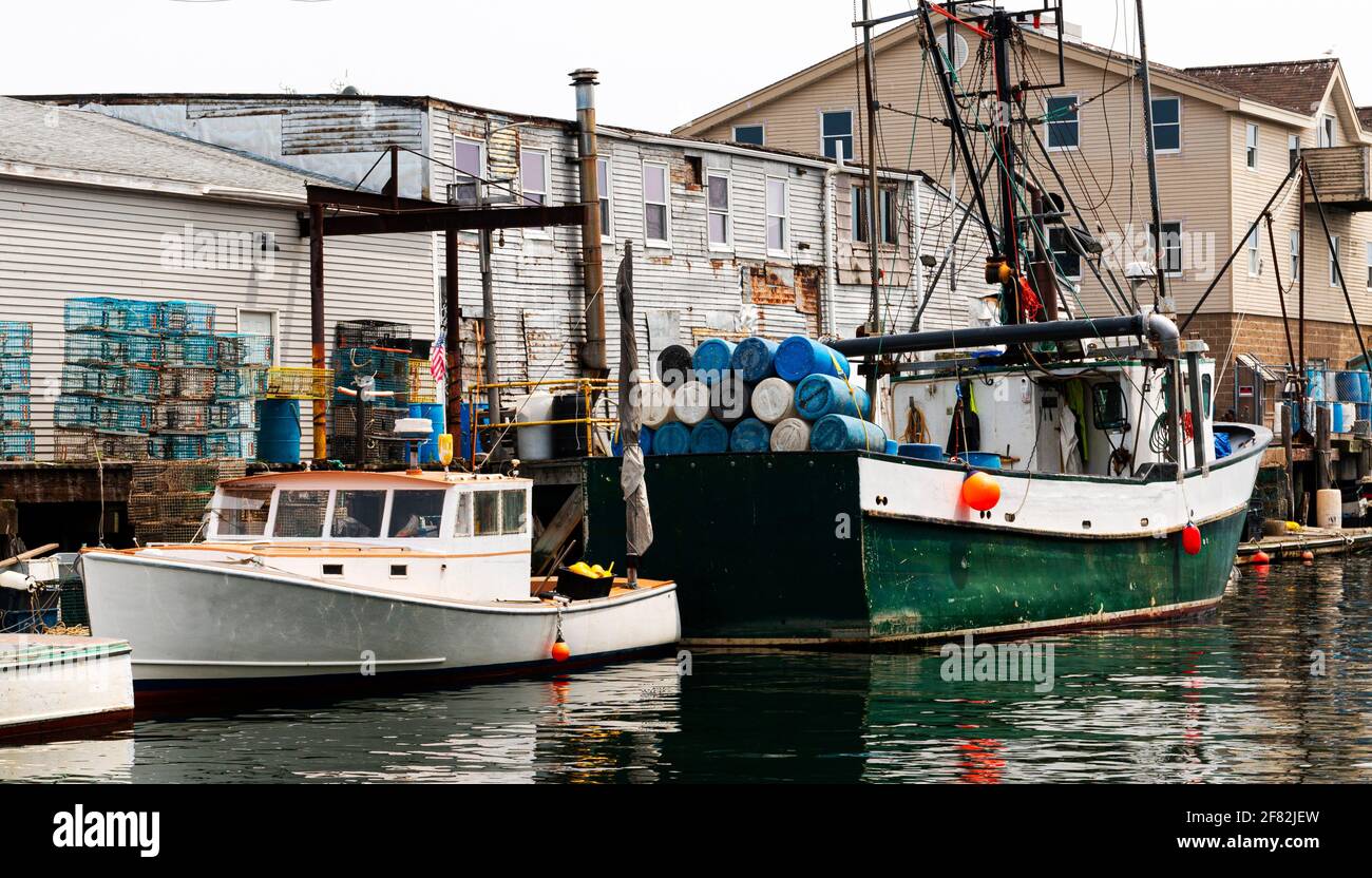 Commercial fishing boats docked behind buildings with colorful lobster ...