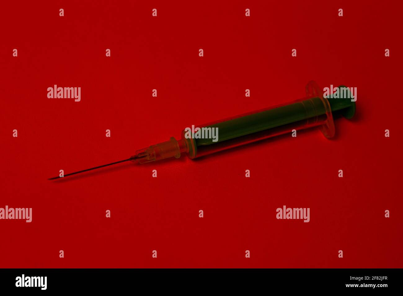 syringe on a red background, danger of infections, fight against speed ...