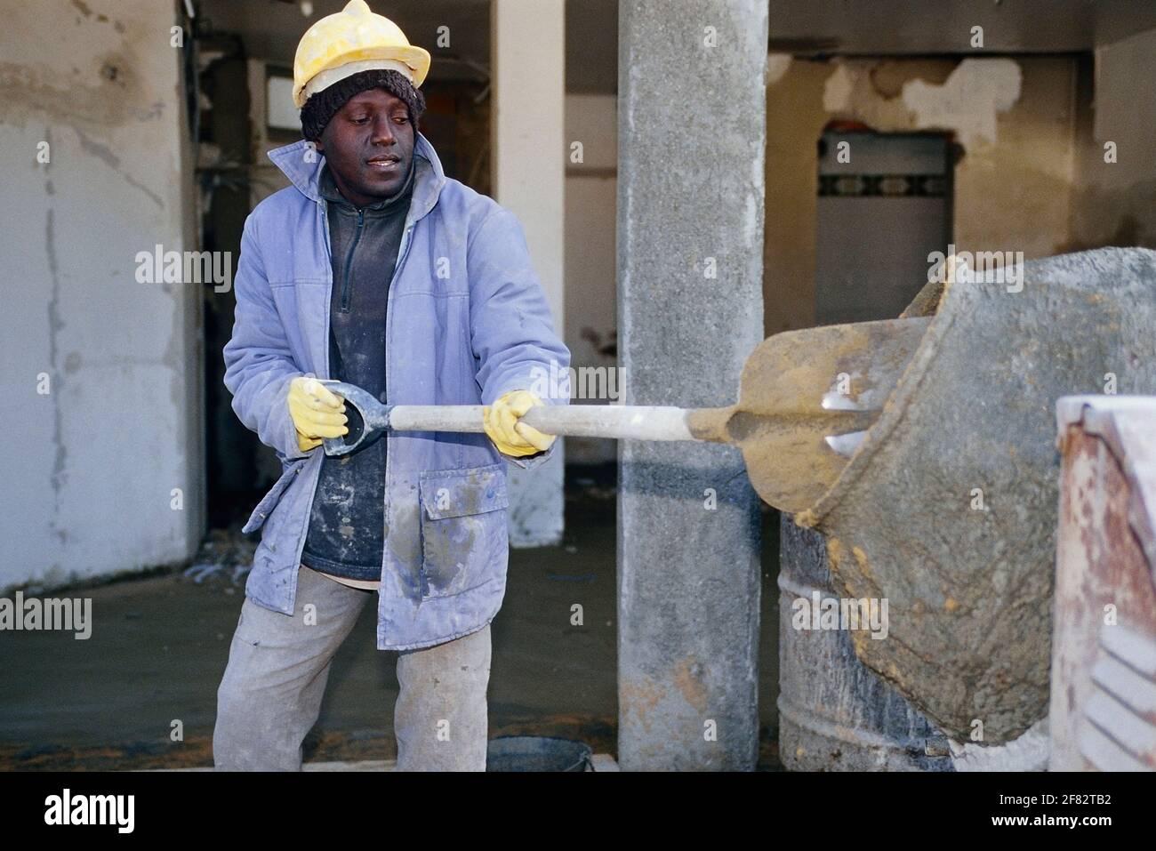 A black construction worker mixing cement Stock Photo - Alamy