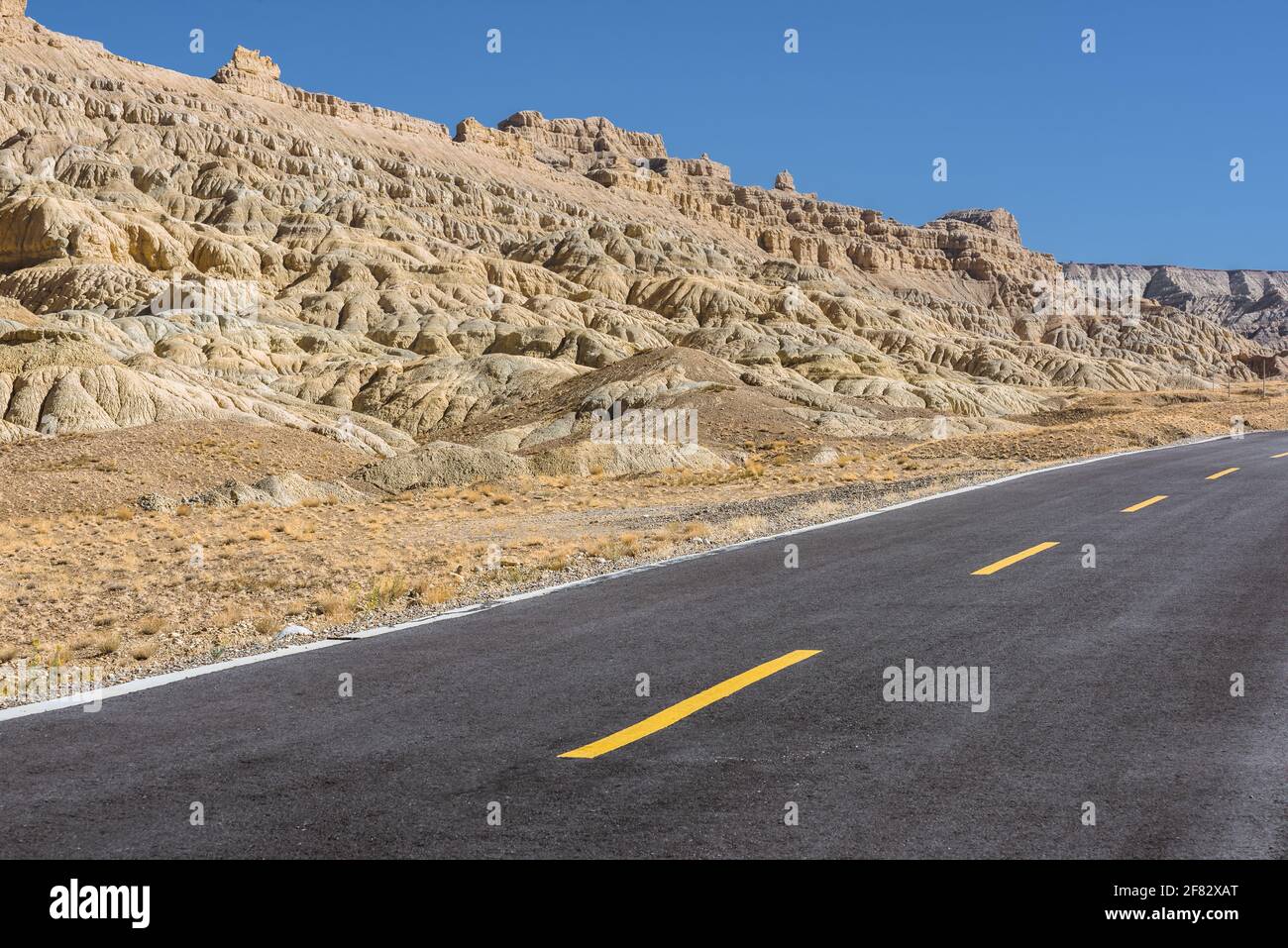 A section of tarmac road in the eroded landscape and rock towers of ...