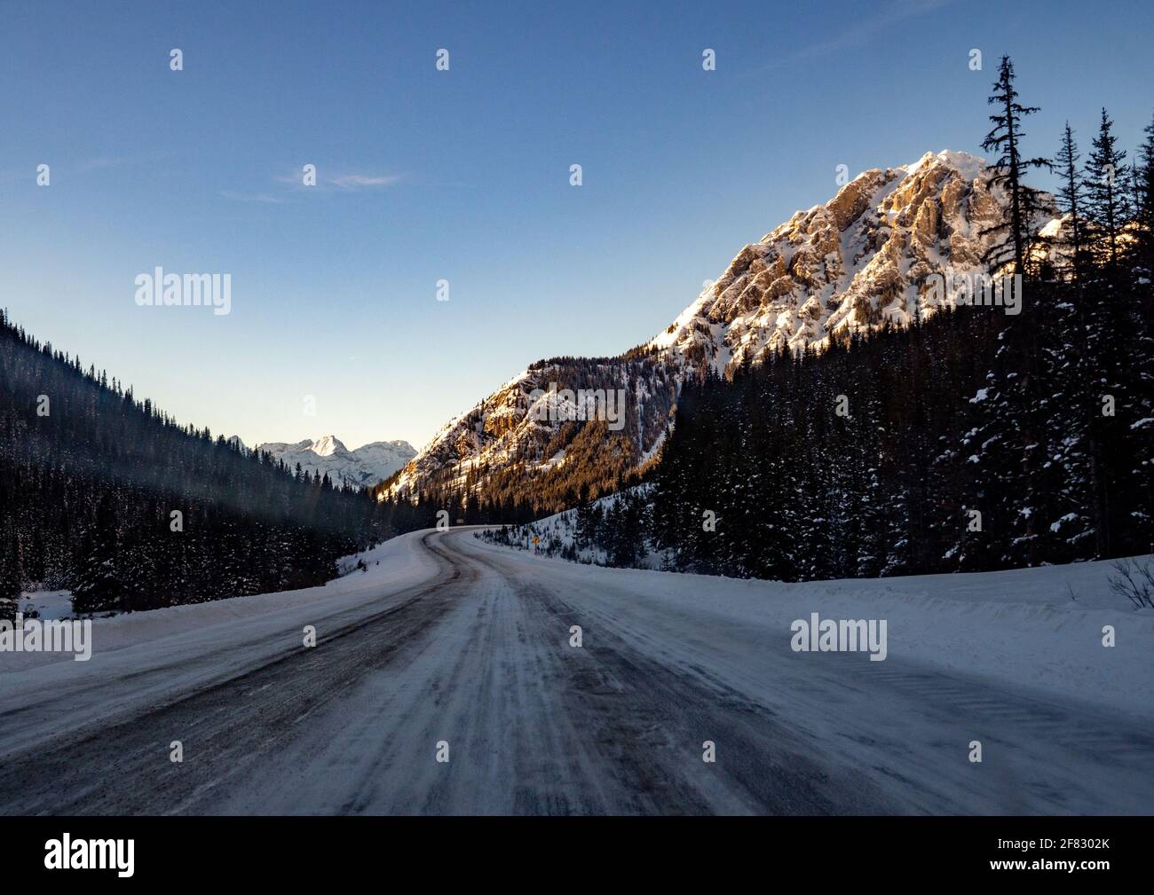dangerous iced road in the mornings in summer with a mountain peak ...