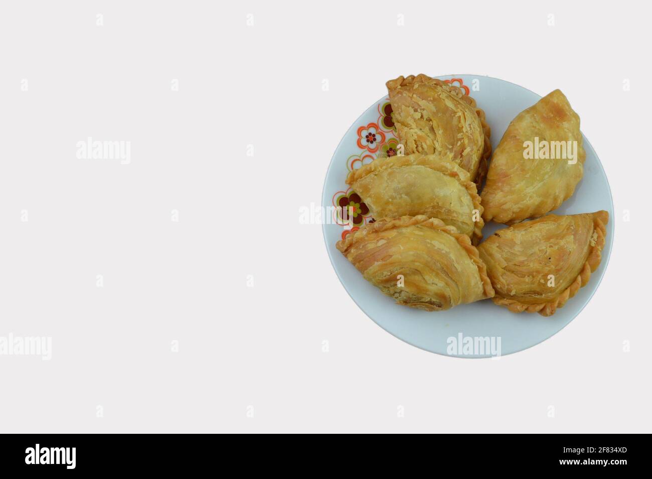 Curry puff pastry on a white plate over white background Stock Photo ...