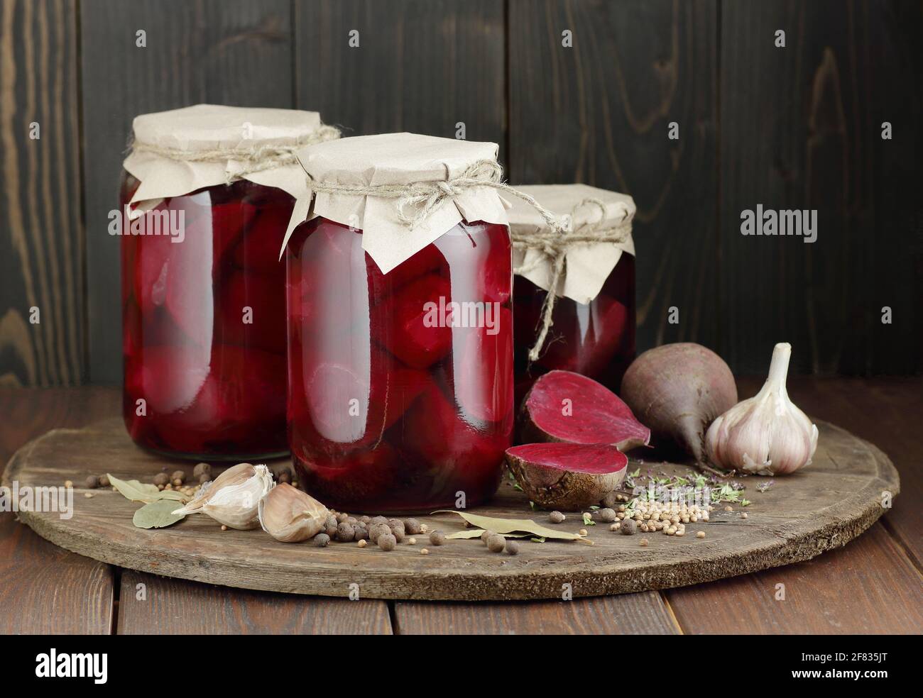 Canned beetroot in glass jars on rustic wooden background, closeup ...