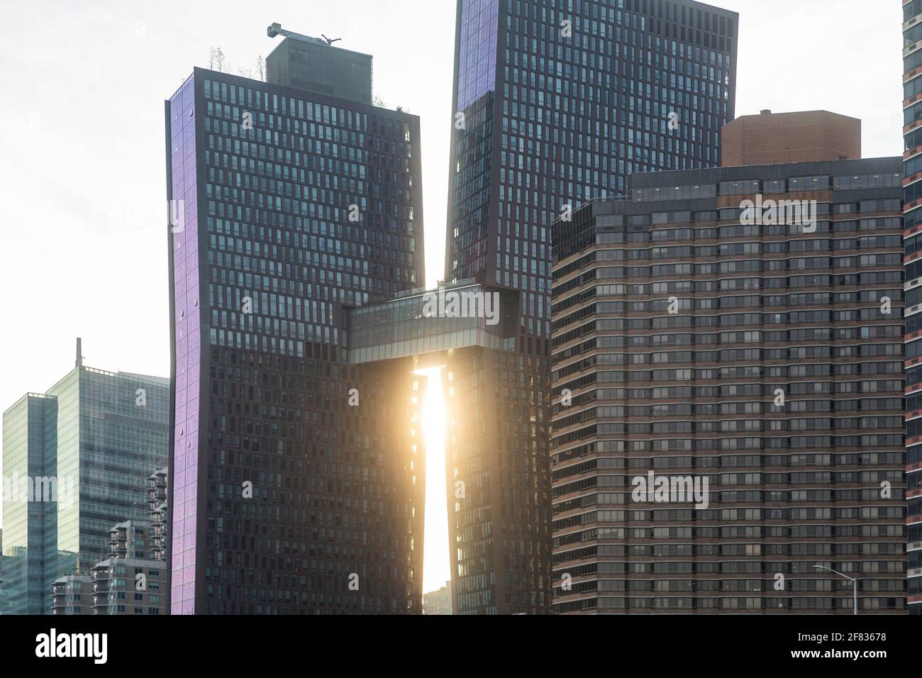 view of tall buildings with the sun shining in between Stock Photo - Alamy
