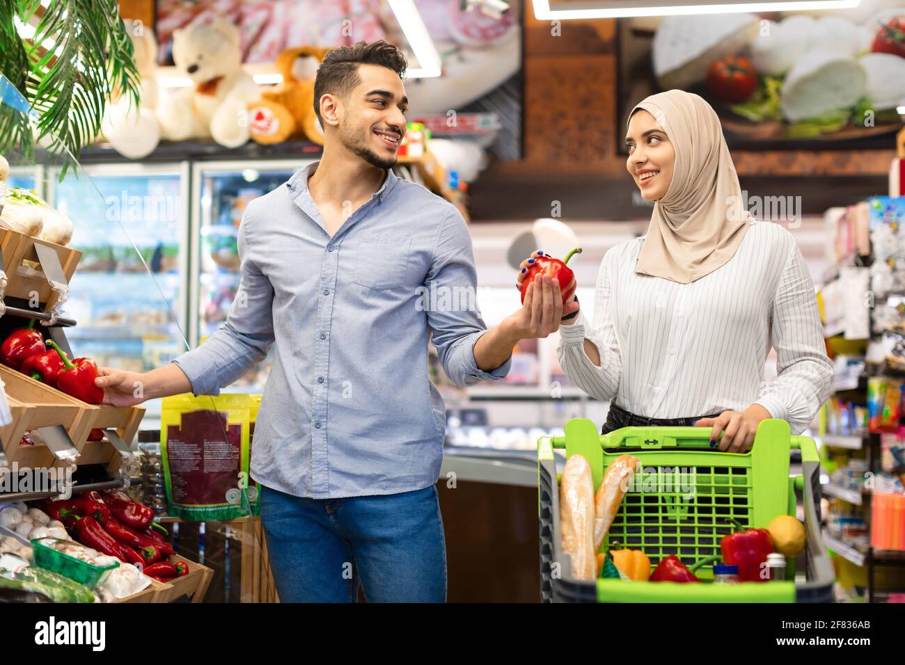Muslim Family Couple On Grocery Shopping Choosing Vegetables In ...