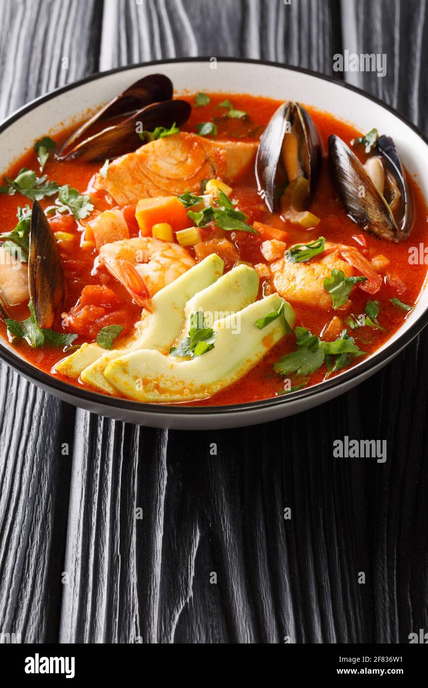 Sopa de Mariscos tomato soup with seafood and vegetables close-up in a ...