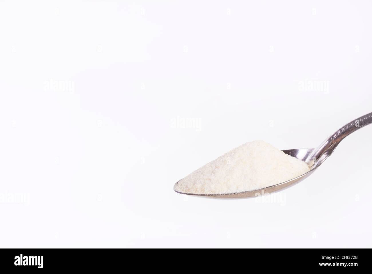 Collagen powder in spoon - white background Stock Photo - Alamy