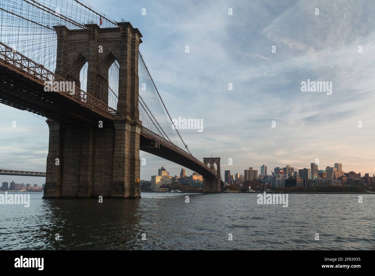 Tall suspension bridge made of stone over water in summer with tall ...