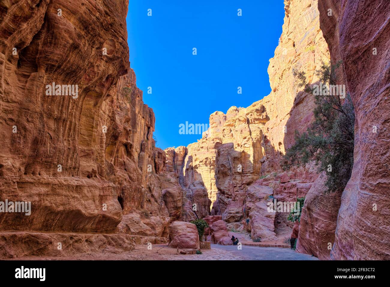 Blue skies and red rocks tower over the pathways and roads in the ...