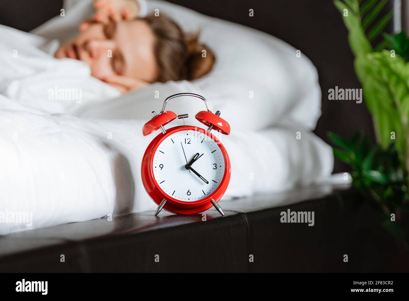 sleepy young millennial woman waking up in white bed yawning rubbing ...