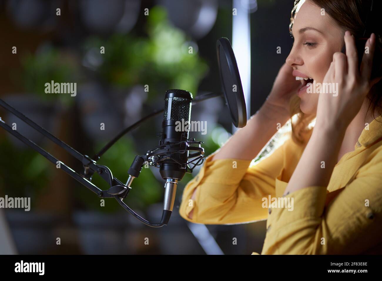 Side view portrait of attractive young woman in modern headphone ...