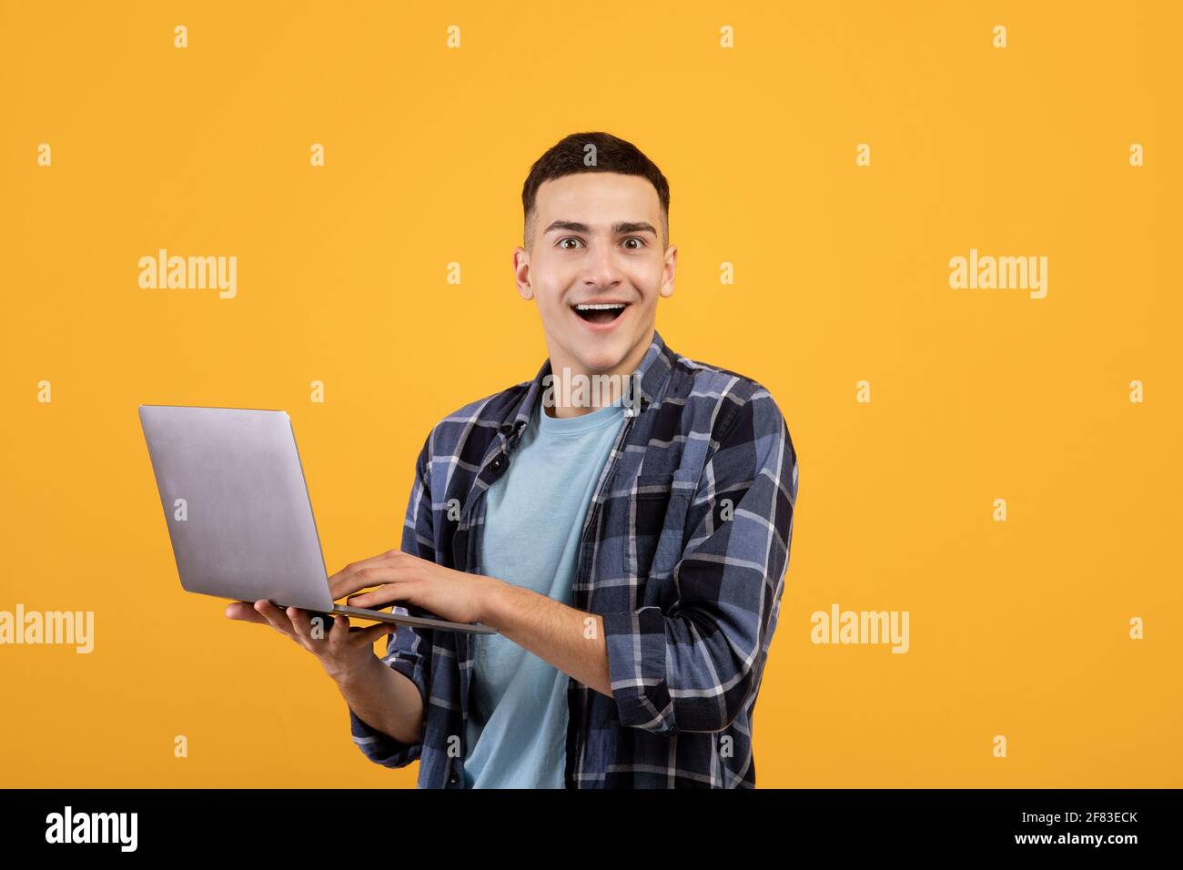 Excited guy looking at laptop screen, opening mouth in shock, watching ...