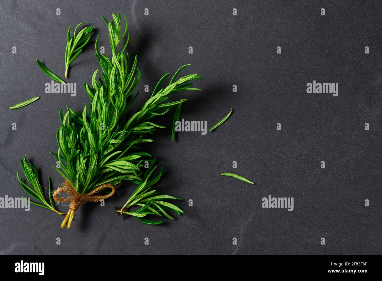 Branch of fresh rosemary on black table background. Rosemary is a rich ...