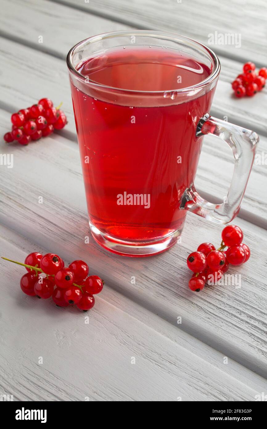 Compote with red currants in the glass cup on the grey wooden ...