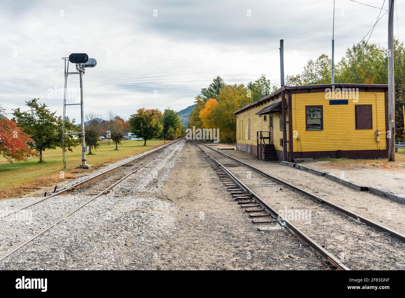 Weathered wooden train station along a mountain railroad on a cloudy ...