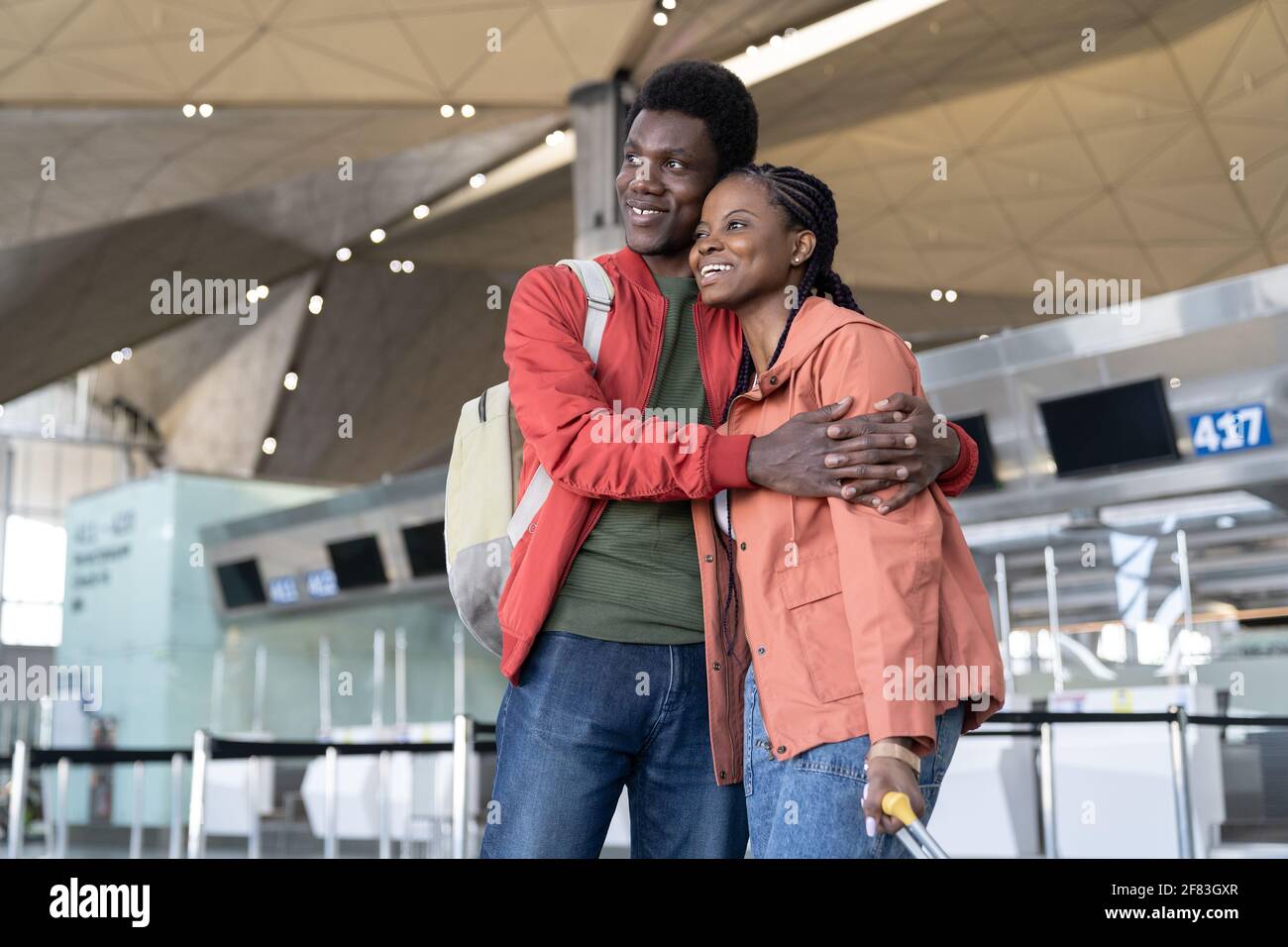 Happy black couple wait plane in airport. Young african man and woman ...