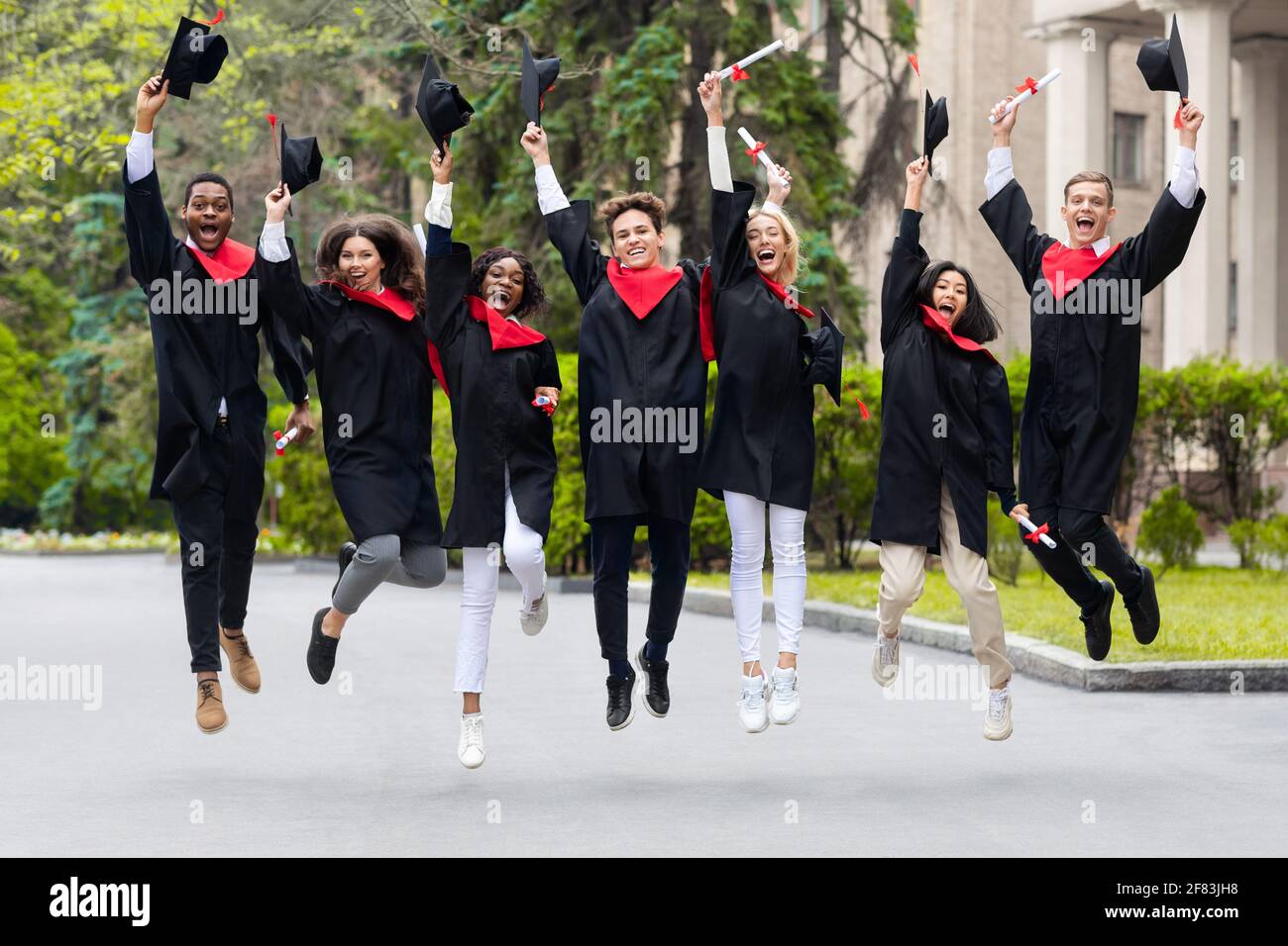 Happy students celebrating graduation from university, jumping up Stock ...