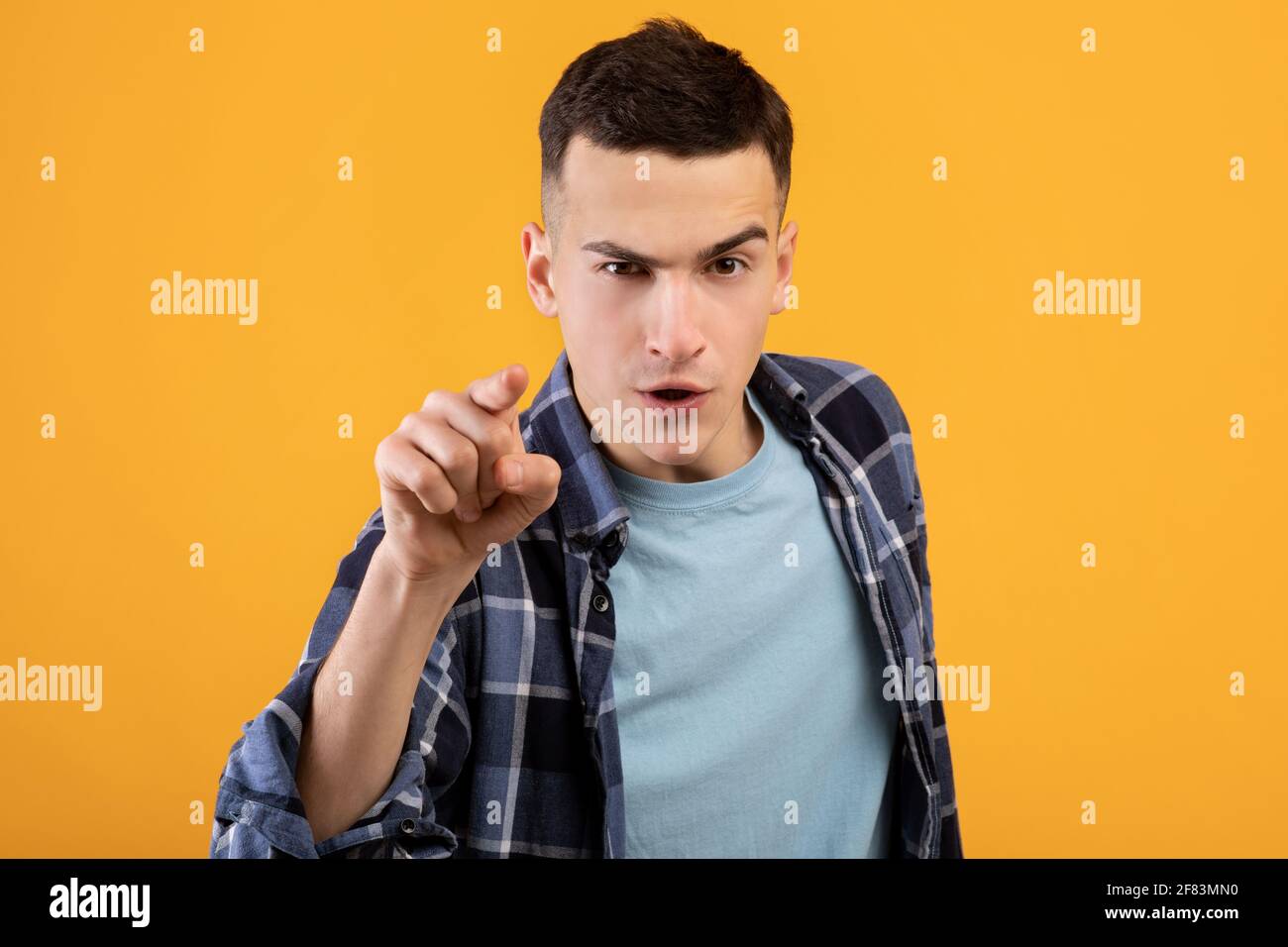 Angry young man pointing finger at you in accusation, saying It's your ...