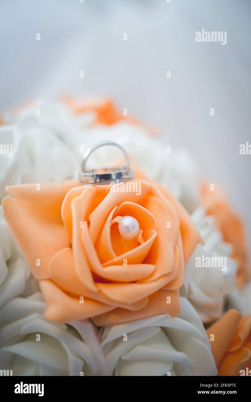 A vertical shot of two wedding rings put on a flower bouquet Stock ...