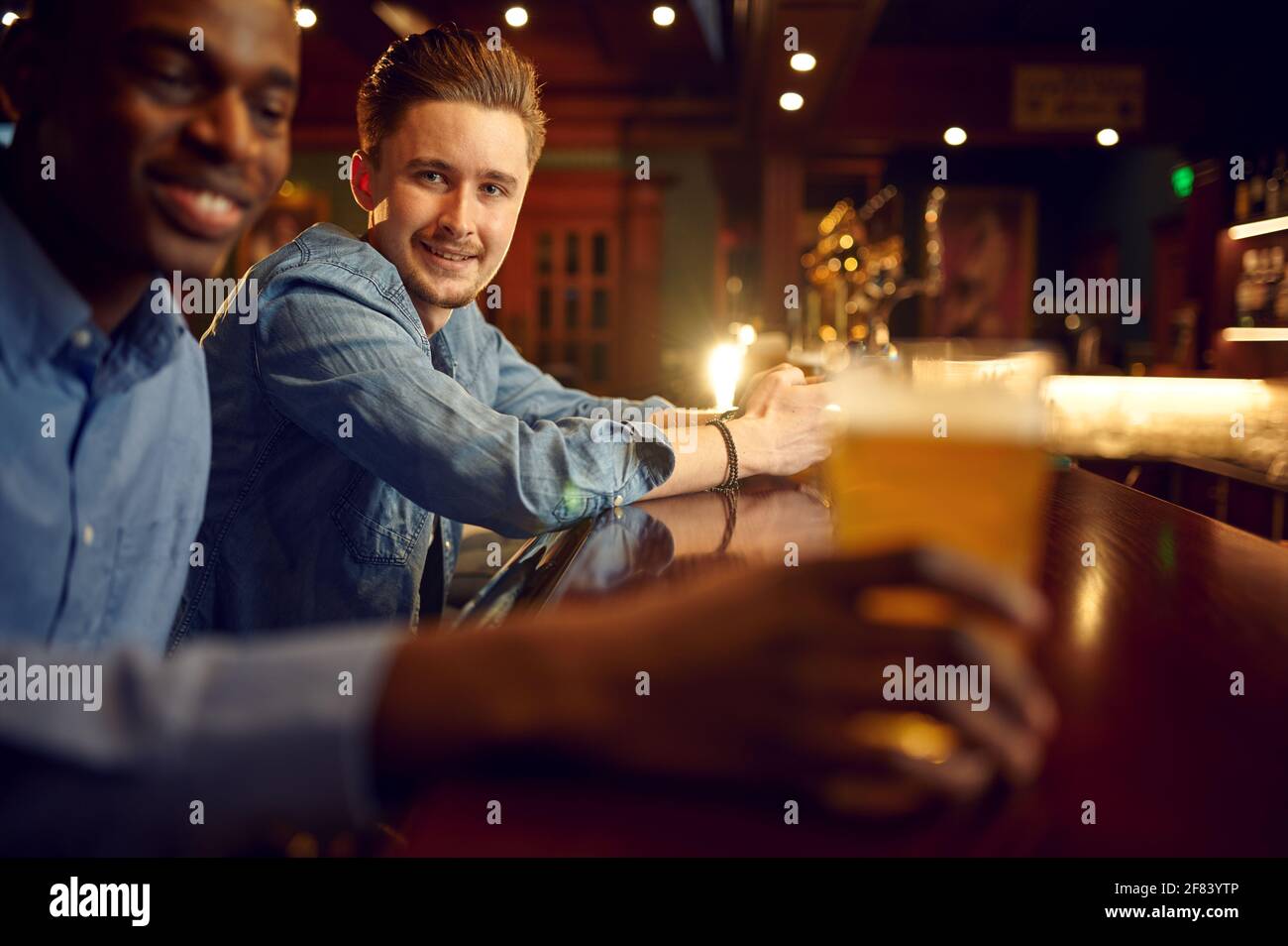 Two male friends leisures at the counter in bar Stock Photo - Alamy