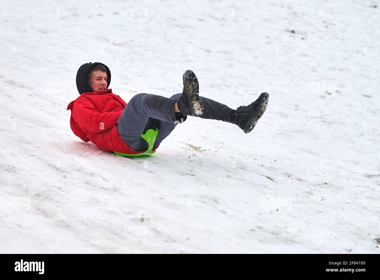 Moscow - 01.12.2021 - Teenage boy slides on sled, rolling down snowy ...