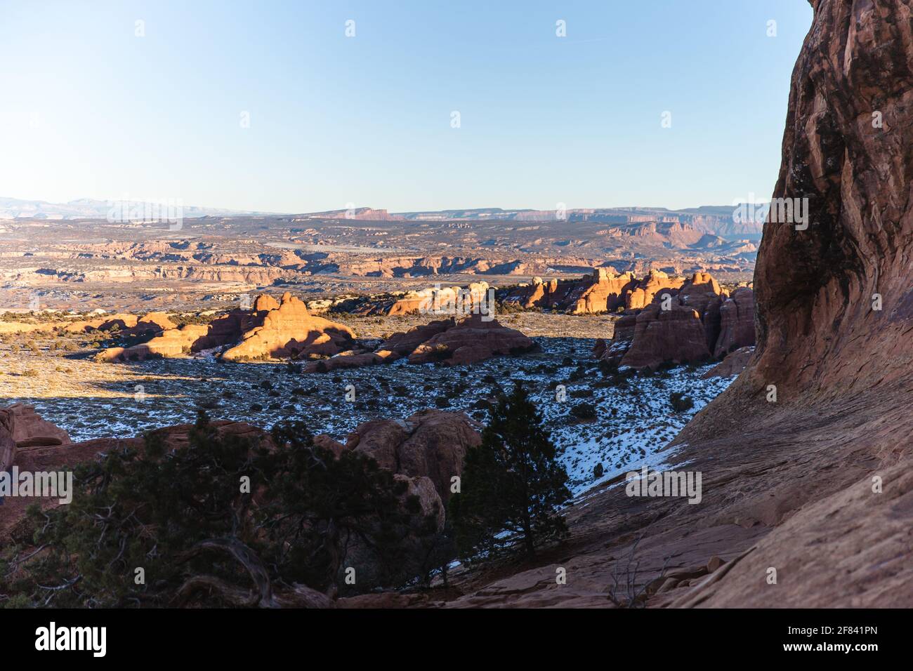 sun in the valley of a red rock desert in winter with snow on the ...