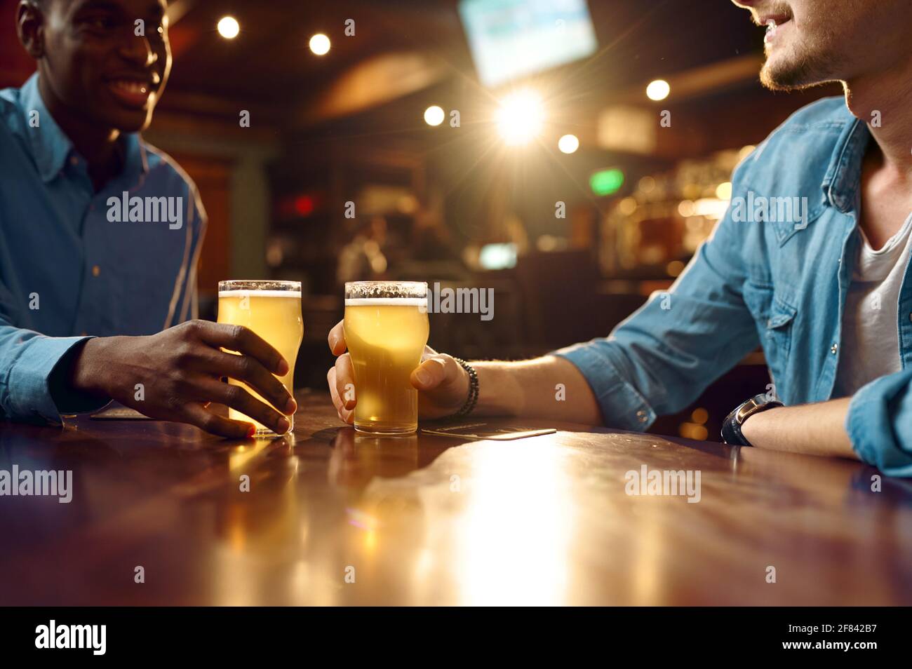 Two male friends drinks fresh beer in bar Stock Photo - Alamy
